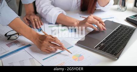 Business team using a calculator to calculate the numbers on his desk ...