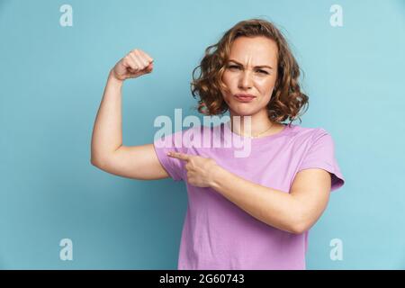 Young ginger displeased woman pointing finger at her face isolated over ...
