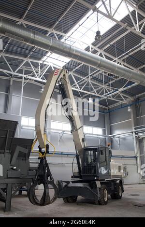 Waste sorting and recycling plant. Loader and grab crane are handling ...