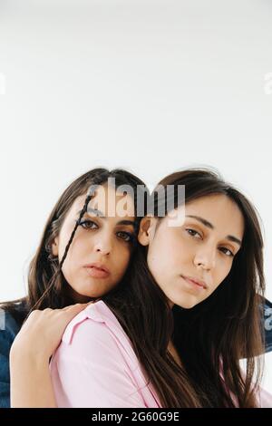 young armenian woman leaning on shoulder of friend while sitting on ...