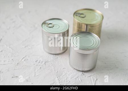 many unopened tin cans with meals such as meat and fish on the table ...