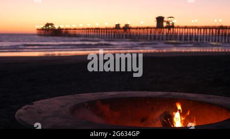 Campfire pit by Oceanside pier, California USA. Camp fire on ocean ...