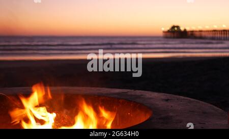 Campfire pit by Oceanside pier, California USA. Camp fire burning on ...