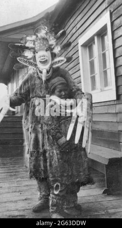 Eskimo medicine man exorcising evil spirits from a sick boy in Alaska ...