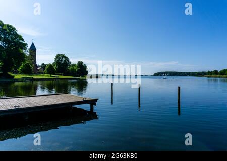 A view of the Maribo Cathedral and Maribo Lake with a wooden dock in ...