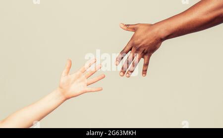 Helping hands, Rescue gesture. African and caucasian hands. Giving a ...