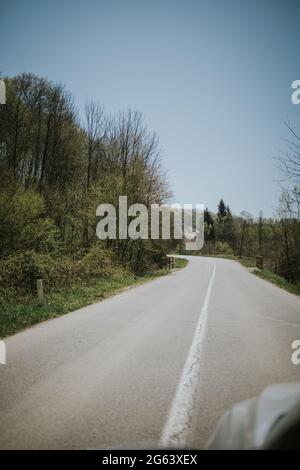 Vertical shot of an empty highway amidst autumn leaves Stock Photo - Alamy