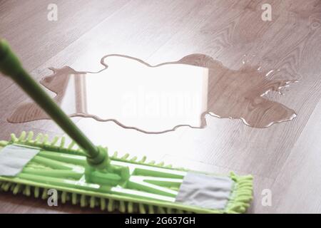 Cleaning a floor with a mop and spilled liquid Stock Photo - Alamy