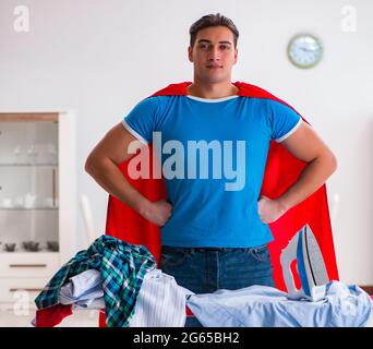 The super hero man husband ironing at home helping his wife Stock Photo ...