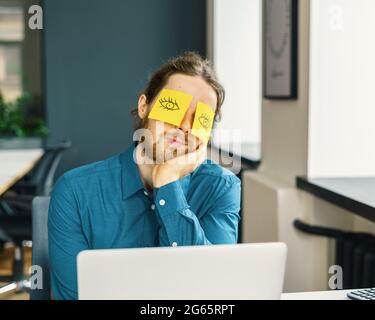Man, sticky notes and sleeping in office, exhausted and professional ...