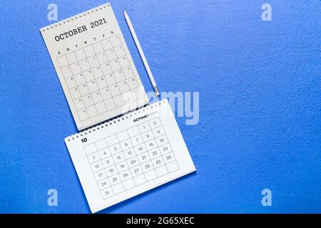 Flip paper calendars and pencil on dark wooden background Stock Photo ...