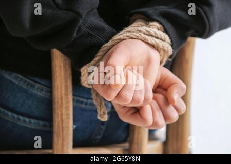 Female hostage sitting on chair against white background Stock Photo ...