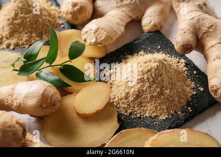 Heaps of ginger powder and roots on light background Stock Photo - Alamy