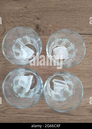 four empty glasses of ice on a wooden table Stock Photo - Alamy