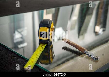 The construction glass cutter is lying on a glass table. Tool on a ...