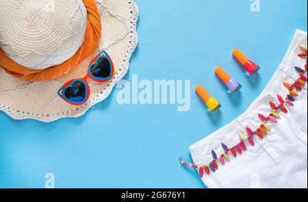 Flat lay composition with hat, sunglasses and seashells on a blue ...