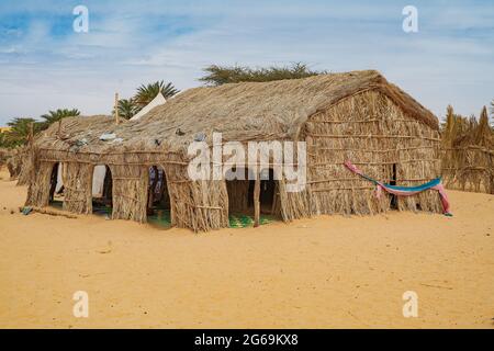 African straw hut in the sand isolated over white Stock Photo - Alamy