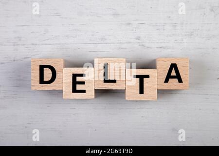wooden blocks with the word delta and red figurines building a symbol ...