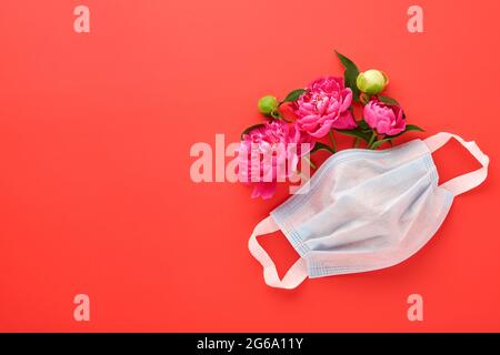 Protective medical face mask with peonies flowers on blue background ...
