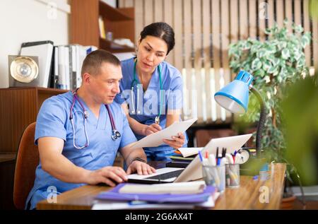 Two doctors checking patient papers in clinic Stock Photo - Alamy