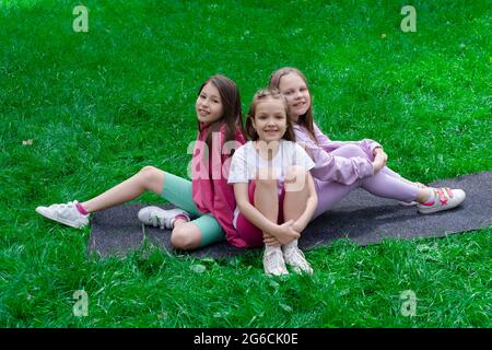 Three pretty tween girls laughing together outdoors in fall colors ...