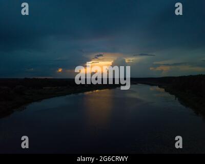 A mesmerizing sunset view over the lake with silhouetted hills ...