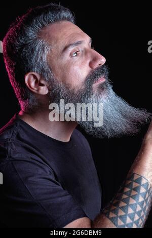 mature man with beard and trendy hairstyle hold gift package ...