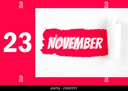 November. Month, Calendar month. Red Hole in the white paper with torn ...