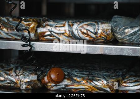 Frozen sprat briquettes in a thawing process in a defrosting chamber. A ...