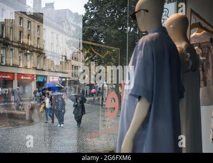 People walk past a summer clothes shop at Eminonu commercial district ...