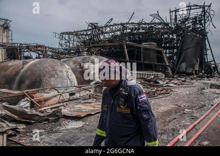 A Thai firefighter walks next to damaged structures caused by an ...