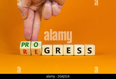 Regress or progress symbol. Businessman turns wooden cubes and changes ...