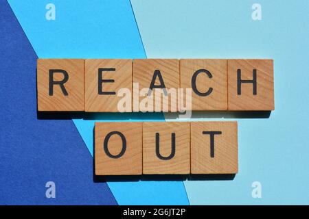 Reach Out, words in wooden alphabet letters isolated on orange ...