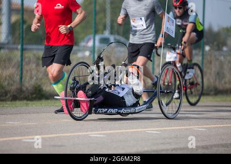 Disabled Athlete who Trains with her Hand Bike with Cyclist and Runners ...