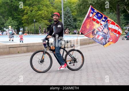 A Dominican American Trump supporter rides his bike displaying a large ...