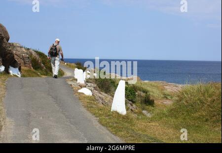 A man walks along the Baltic Sea during rain falls in Timmendorfer ...