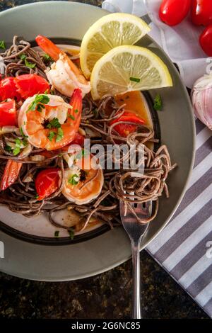 Italian shrimp Gamberoni Aglio e Olio with black pasta and cherry ...