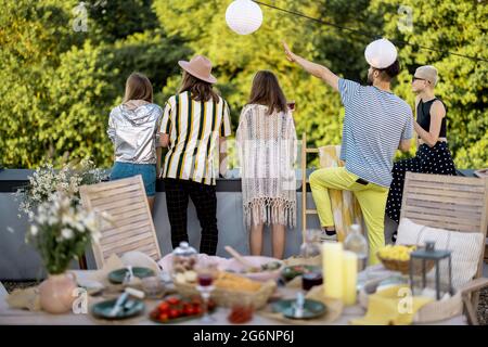 Group of friends enjoying outdoors at roof. Young friends at sunset on ...