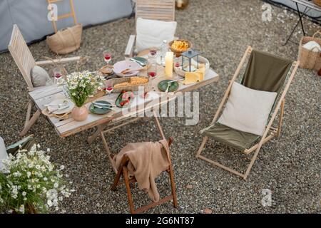 Beautifully served wooden table with food and dishes in natural boho ...