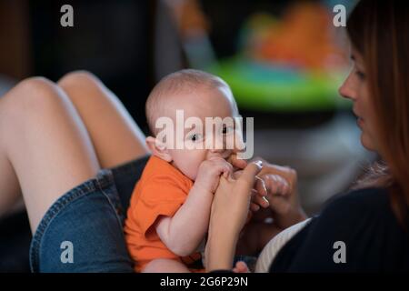 Baby biting his mother's finger Stock Photo - Alamy