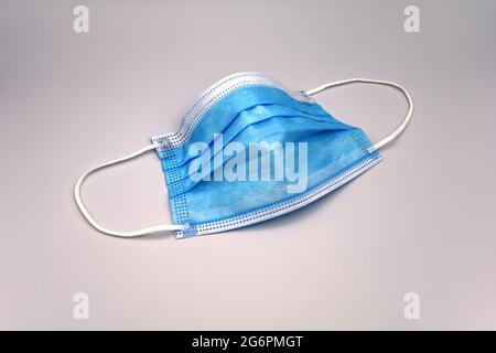 Face medical mask on a gray background. Disposable 3-ply medical mask ...