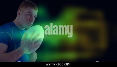 Composition of glowing green blur over male rugby player holding rugby ...
