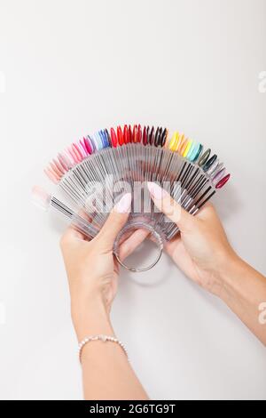 A vertical shot of nail polish small glass bottles on a wooden board ...