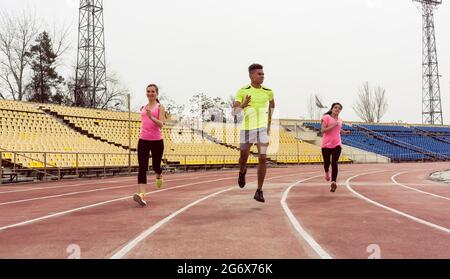 Fit young guy on his mark to start a run. Focused young male athlete ...