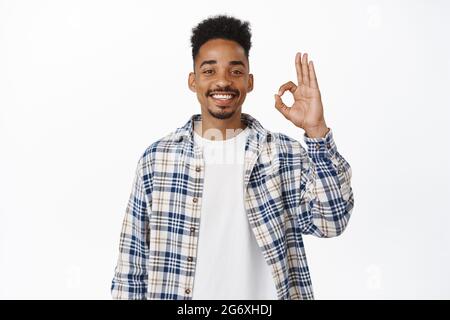 Happy guy say yes, smiling and showing okay signs, like good product ...