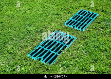 2 manhole drainage grates on the lawn with green grass septic tank ...