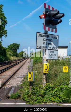 warning lights at an automatic half barrier railway level crossing with signs warning of another ...