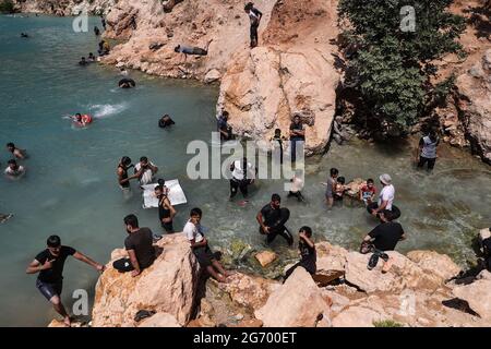 Darkush, Syria. 09th July, 2021. Syrians swim in the water of Asi ...