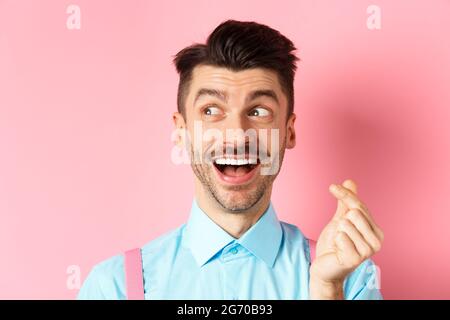 Valentines day concept. Romantic guy showing finger heart and looking ...