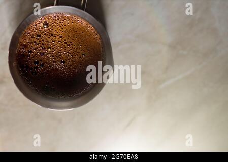 ready-made turkish coffee in a cezva in a turk on the table top view ...